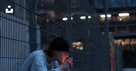 흰색 스웨터와 검은 모자를 쓴 남자가 벤치에 앉아 있다 사진 Unsplash의 무료 밤 이미지