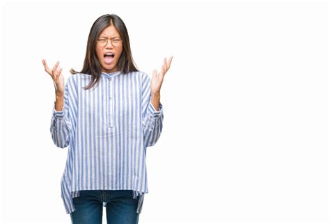 젊은 아시아 여자 미친과 미친 무기와 성공에 대 한 격리 된 배경 위에 제기 하 고 흥분 비명 눈을 폐쇄 우승자 개념 기이함에
