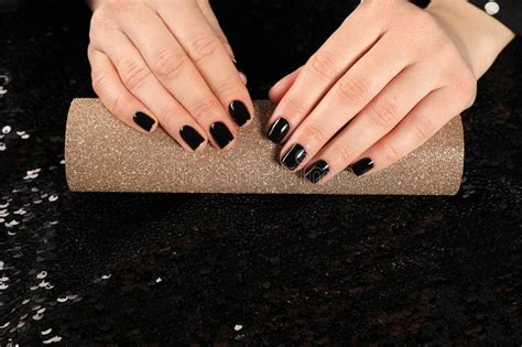 Mulher Que Mostra O Tratamento De Mãos Preto No Papel Brilhante Rolado