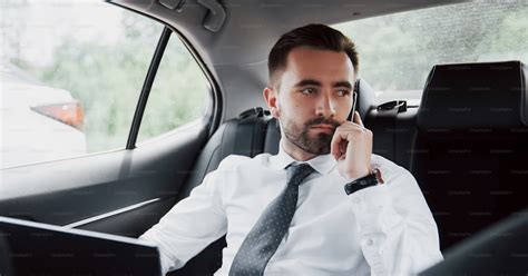 노트북으로 작업하고 차 뒤쪽에 앉아 전화 통화를 하는 젊은 사업가 움직이는 동안 작동하고 시간을 높이 평가합니다 사진 Unsplash의 찾고 이미지