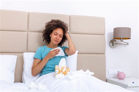 아픈 아프리카 젊은 여자 는 집에서 기침 알레르기 증상을 가진 소파에 앉아 아픈 알레르기 성 흑인 소녀에 앉아 감기 재채기를 잡은 발열을 가지고 코를 불고 담요로 덮여 있어