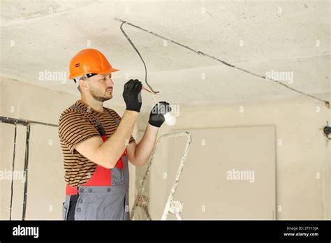 Electric In Uniform Protective Gloves And Hard Hat Checking And Measuring The Presence Of