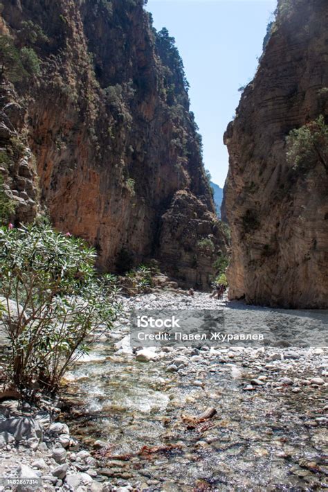 화창한 날 협곡을 통과하는 길을 따라 산의 전망 세계에서 가장 깊은 협곡 중 하나 인 산의 경사면에 누워있는 그리스 산맥의 협곡 인 협곡의 전망 경관에 대한 스톡 사진 및