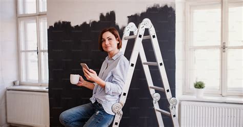 커피 한 잔과 스마트폰 페인팅을 한 젊은 창조적인 여성의 초상화는 벽을 검은색으로 칠한다 중소기업의 창업 사진 Unsplash의 사업 이미지