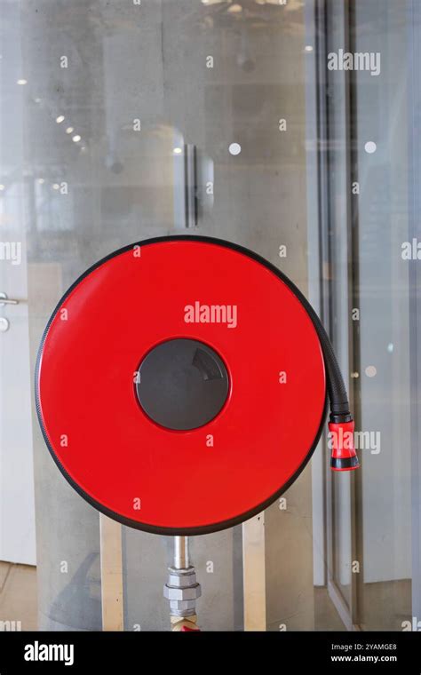 A Striking Red Fire Hose Reel Stands Out Against A Contemporary And