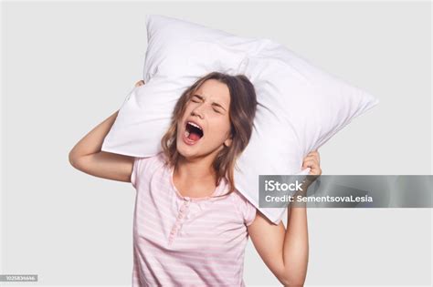 위기의 충격된 여성 닫히고 눈에서 비명 악몽 머리 뒤에 보유 베개 입고 잠 옷 보고 무서운 꿈을 밤에 흰색 배경 위에 절연