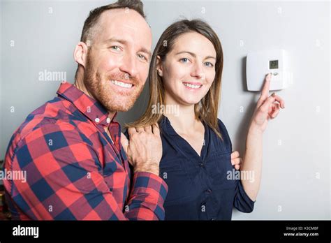 Couple Set The Thermostat At Home Stock Photo Alamy