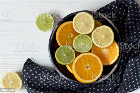 레몬 오렌지와 블루 세라믹 그릇 및 하얀 나무 테이블에 귀여운 수건에 라임 슬라이스 수 분이 많은 과일 개념 건강 한 음식