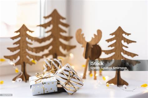 크리스마스 사슴 집에서 흰색 창턱에 장식 황금 선물 상자와 나무 순록 장난감 새해 복 많은 2022 수제 피규어 사슴과 전나무 나무 에코 스타일 Diy 0명에 대한 스톡