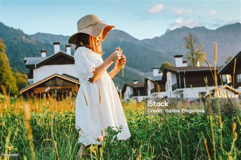 산에서 아름다운 집의 배경에 꽃을 따기 밀짚 모자에 아름다운 낭만적 인 십대 소녀 일몰시골 장면 소치에 대한 스톡 사진 및 기타 이미지 Istock