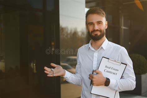 Male Realtor Standing Outside Residential Property Holding Keys Stock