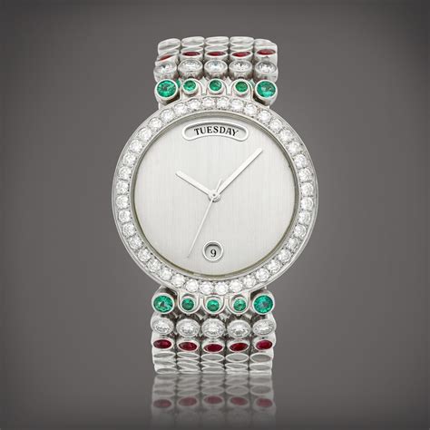 A Platinum Diamond Emerald And Ruby Set Bracelet Watch With Day And