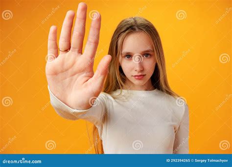 Teen Girl Extend Hand In Block Gesture Against Yellow Background Stock