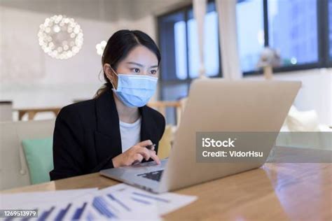 얼굴 마스크를 쓰고 집에서 노트북을 가지고 일하는 아시아 여성 18 19세에 대한 스톡 사진 및 기타 이미지 18 19세