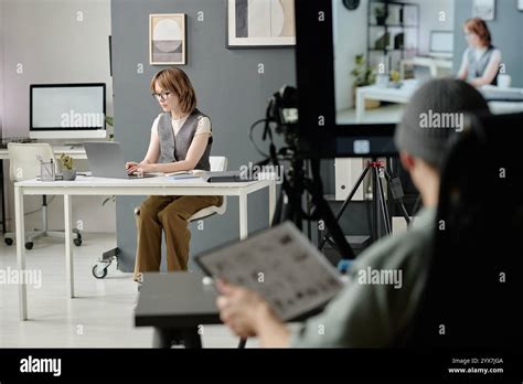 Elegant Actress Sitting At Work Desk And Typing On Keyboard While