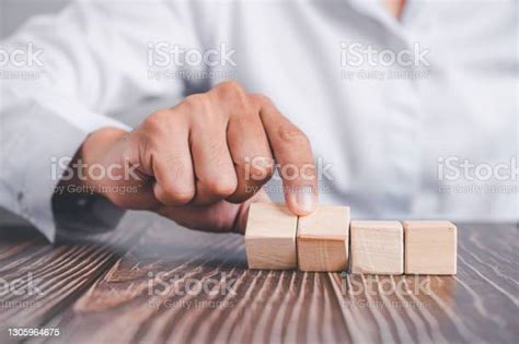 파란 셔츠를 입은 사업가가 빈 나무 블록을 손으로 정리했다 흰색 나무 테이블에 배치됩니다 비즈니스 전략 및 실행 계획 공간을