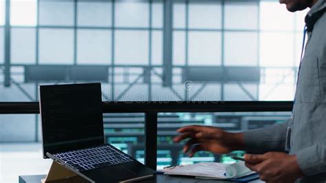 Technician In Data Center With Laptop And Tablet Integrating Ai