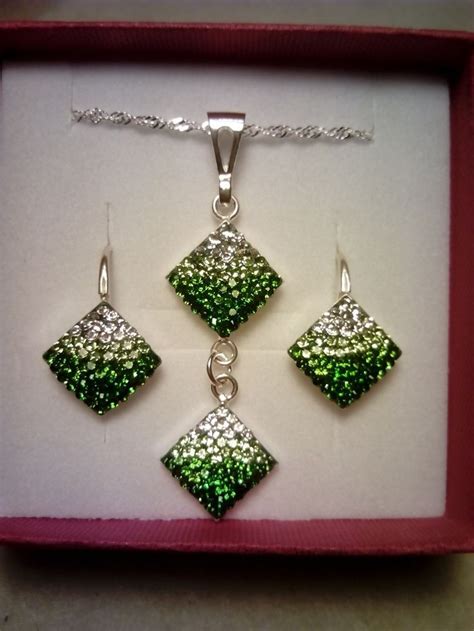 Three Pieces Of Green And White Jewelry In A Pink Box With Silver Chain