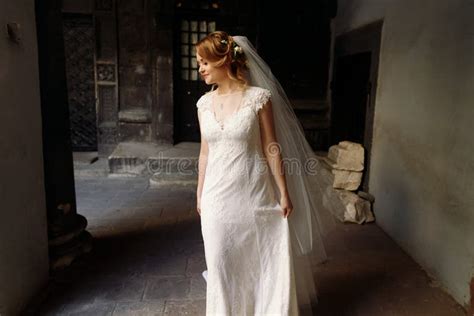 Beautiful Blonde Bride In Elegant White Lace Wedding Dress And Veil