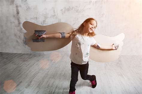 어린 소녀는 조류에서 활약 벽의 Thebackground에 대 한 골 판지 날개와 작은 소녀 가정의 방에 대한 스톡 사진 및 기타 이미지 Istock