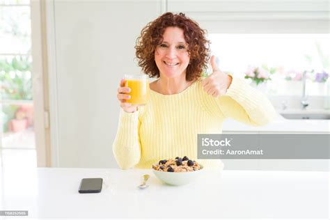 아침에 건강한 아침 식사를 하는 시니어 여성 집에서 행복한 큰 미소로 확인 사인을하고 손가락으로 엄지 손가락 우수한 표지판 가정 생활에 대한 스톡 사진 및 기타 이미지