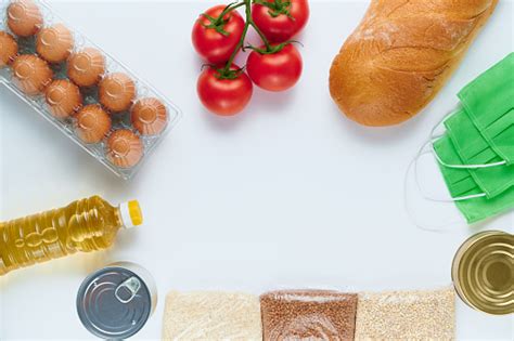 플랫레이 탑 뷰 푸드 포토 빨간 토마토 빵 한 덩어리 의료 장갑 의료 용 마스크 해바라기 기름 통조림 식품 비스킷 쿠키 쌀 메밀