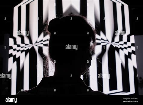 Woman Looking At Large Cube Screen With Rotating Hypnotic Optical Illusion Stock Photo Alamy