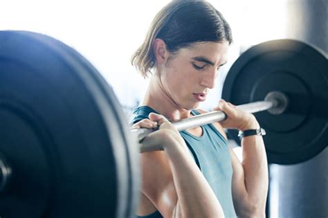 피트니스 체육관 및 남성은 강하거나 강력한 팔 근육과 보디 빌딩을 위해 바벨 어깨 프레스 운동을합니다 보디빌더 근력 운동과 훈련과 노력이 포함된 역도 운동 20 24세에