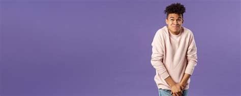 젊은 남자의 초상화는 대기열에 있는 줄에 서 있는 동안 시계를 보고 오줌을 참을 수 없어야 합니다 무료 사진