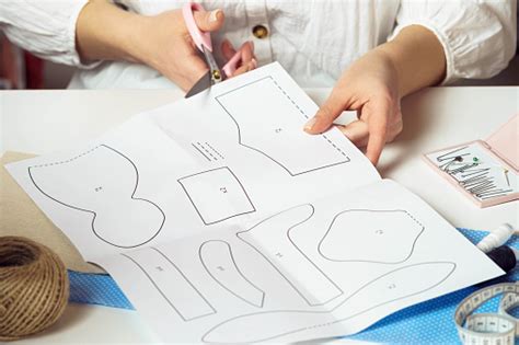 자른 이미지 여성 디자이너 고용주는 옷과 장난감을 만들기 위해 숫자가 있는 종이 시트에서 패턴을 잘라내는 손을 잡습니다 Diy에 대한 스톡 사진 및 기타 이미지 Istock