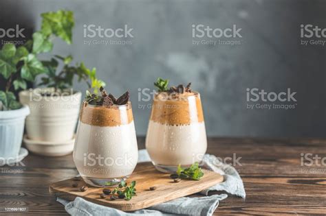 달고나 거품 커피 트렌드 한국 음료 라떼 에스프레소와 타임과 다크 초콜릿으로 장식 된 커피 거품을 가진 두 잔 어두운 나무