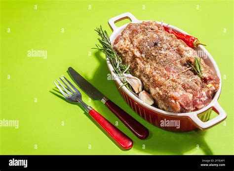 Raw Pork Roll Stuffed With Garlic And Carrots In A Ceramic Roasting