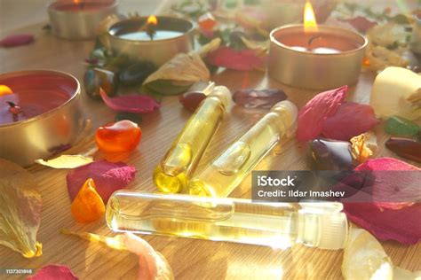 에센셜 스파 오일 장미 꽃 꽃잎과 나무 배경에 화려한 보석 촛불 굽기 바람에 대한 스톡 사진 및 기타 이미지 바람 향기로운