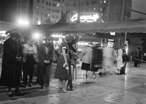 People Browse The Footprints And Handprints In The Forecourt Of Grauman