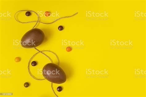 노란색 배경에 초콜릿 부활절 달걀과 초콜릿 과자를 갖춘 플랫 레이 구성 위에서 보기 텍스트에 대한 빈 공간 개념에 대한 스톡