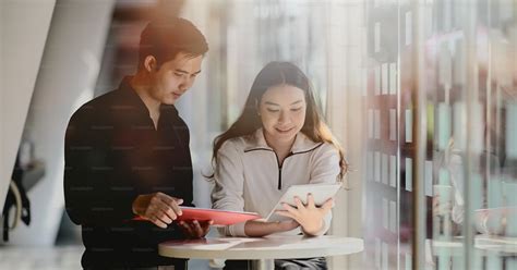 젊은 비즈니스 여성과 아시아 남성이 태블릿에서 함께 일하고 있다 사진 Unsplash의 앉아 이미지