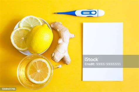 한 잔의 약용 차 생강 레몬은 추운 계절에 면역 체계를 강화 온도계 및 복사 공간 노트시트 노란 배경에 건강과 성분을위한 비타민