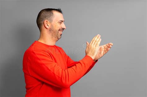 Bearded Hispanic Man In Profile Wearing A Red Jumper Feeling Happy