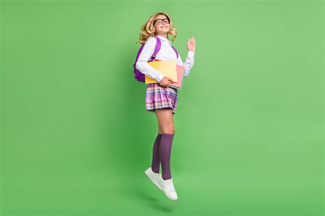 녹색 색상 배경을 통해 고립 된 새로운 학년 레슨을 점프 꽤 쾌활한 소녀의 전체 길이 몸 크기 보기 곱슬 머리에 대한 스톡 사진