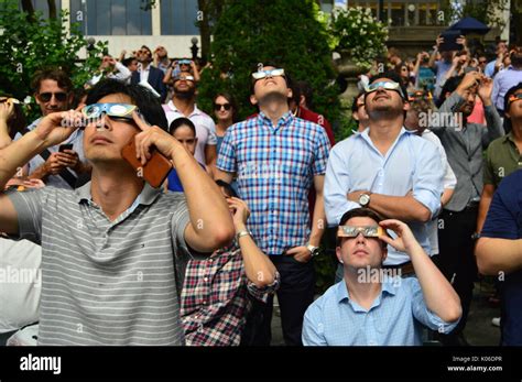 A Crowd Of People Don Their Solar Glasses To View The Solar Eclipse In