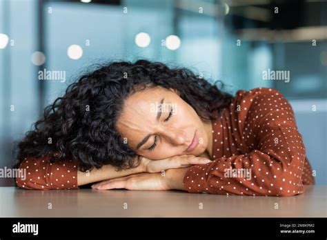 Beautiful Tired Hispanic Woman Sleeping On Desk Close Up Business