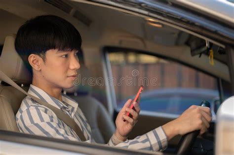 A Man Using His Smartphone While Driving A Car A Man Using Map On His