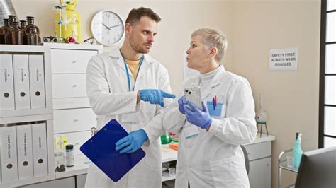 A Woman And A Man Scientists In Laboratory Analyzing Data On A Smartphone Conveying Teamwork