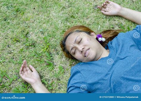 Young Asian Woman Fainting On Grass In Park Because Outdoors Of Hot