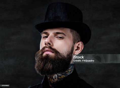 어두운 배경에 고립 된 상단 모자를 쓰고 목에 문신을 한 구식 수염 남자의 클로즈업 초상화 스튜디오 샷 개성 개념에 대한 스톡 사진 및 기타 이미지 Istock