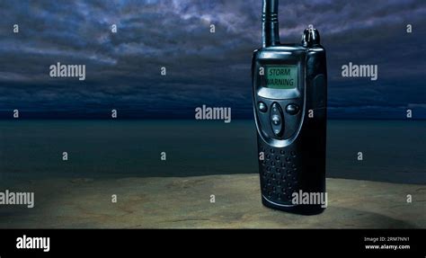 Handheld Transceiver With A Storm Warning Flashing Across The Screen With Clouds Gathering Over