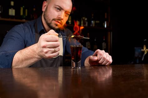 바에서 불타는 쇼 바텐더는 뜨거운 알코올 칵테일을 만들고 바에 불을 붙입니다 바텐더는 불타는 칵테일을 준비합니다 바에 화재 검은색에 대한 스톡 사진 및 기타 이미지 Istock
