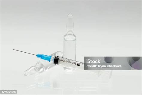 白い背景に分離された針付きの液体およびプラスチックの注射器が付いたガラス薬のアンプル アンプルのストックフォトや画像を多数ご用意