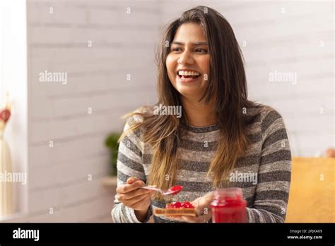 Woman Applying Fruit Jam On Bread During Breakfast Stock Photo Alamy