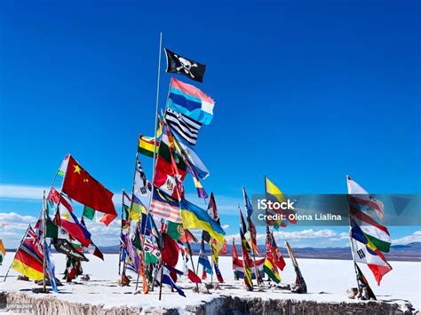 하늘에 깃발 흰색 소금 평평한 사막 살라 드 우유니 볼리비아에 국제 플래그 소금의 마운드는 전 세계에서 온 방문자가 가져온 밝은